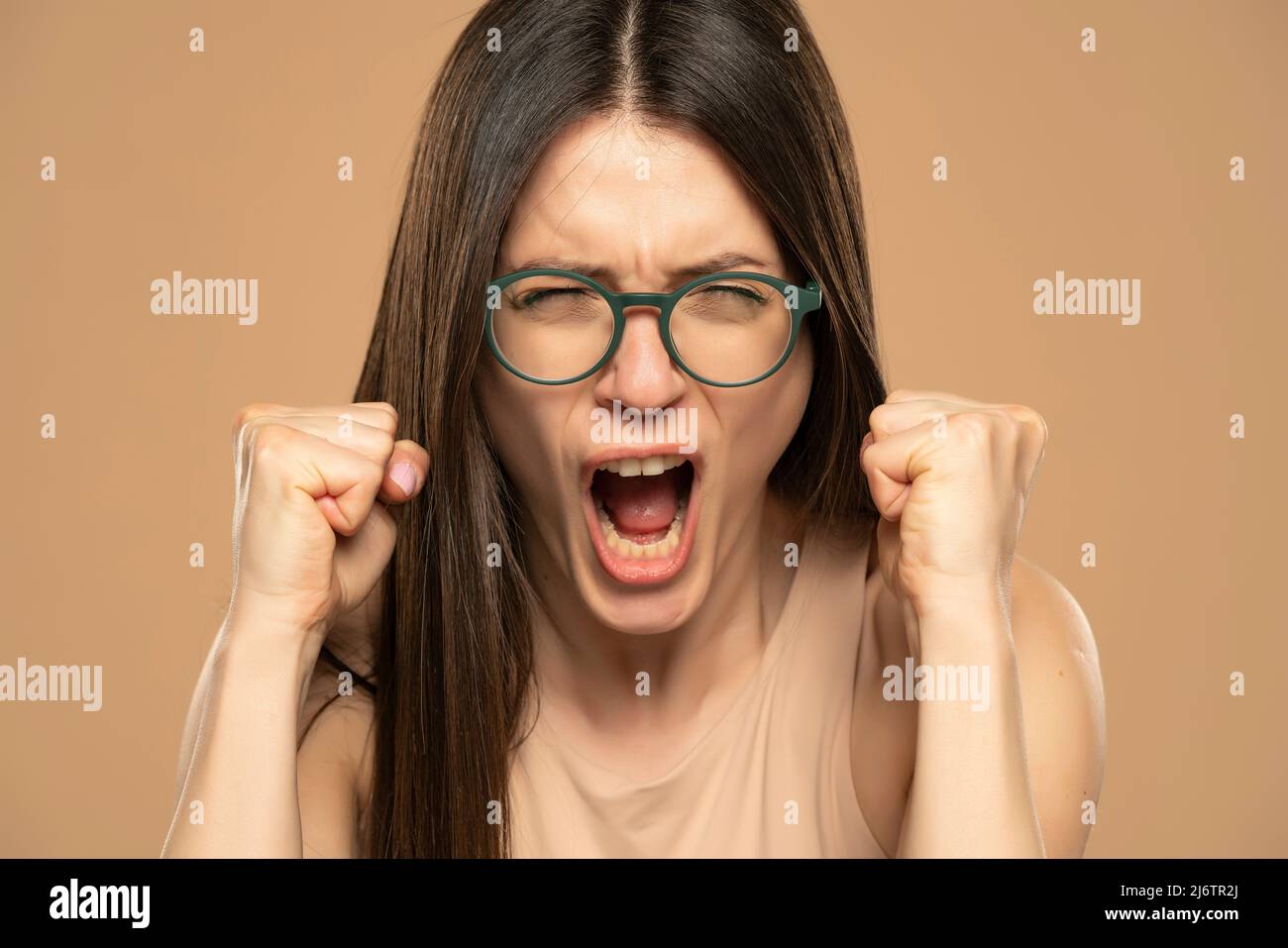 Mad emotional angry woman arguing on you on beige studio background ...