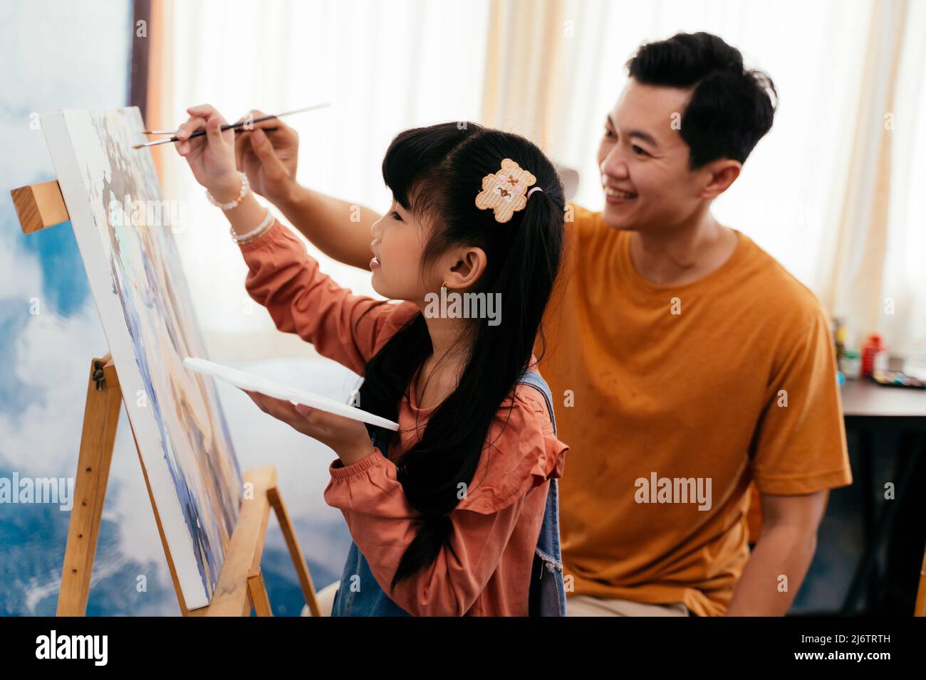 Family of young father teaching his daughter about drawing together ...