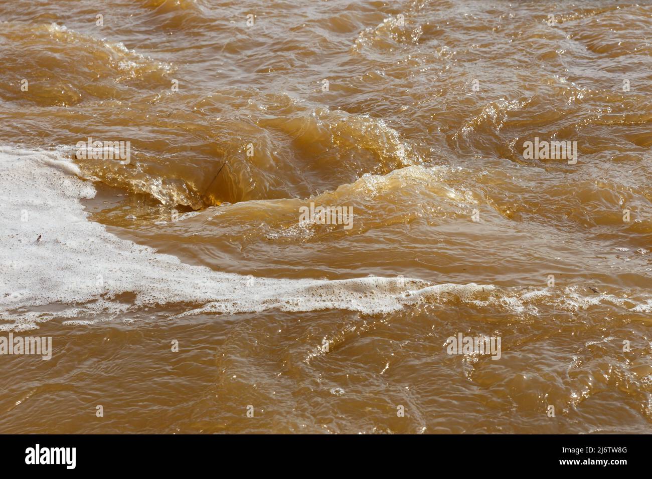 Muddy river water. Dirty muddy water with whirlpool and white foam ...