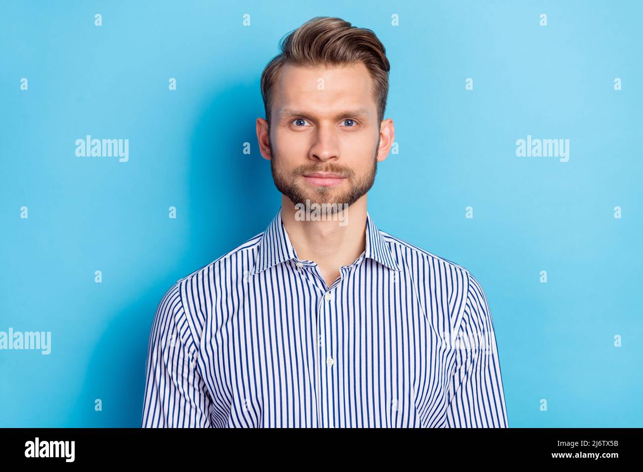 Photo of calm focused person look camera isolated on bright blue color ...