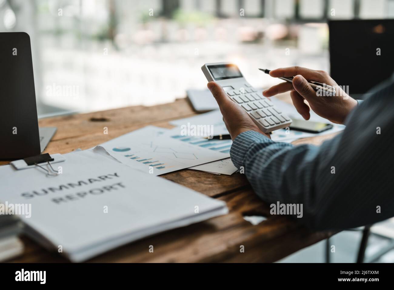 Accountant or bookkeeper working with calculator to calculate business ...