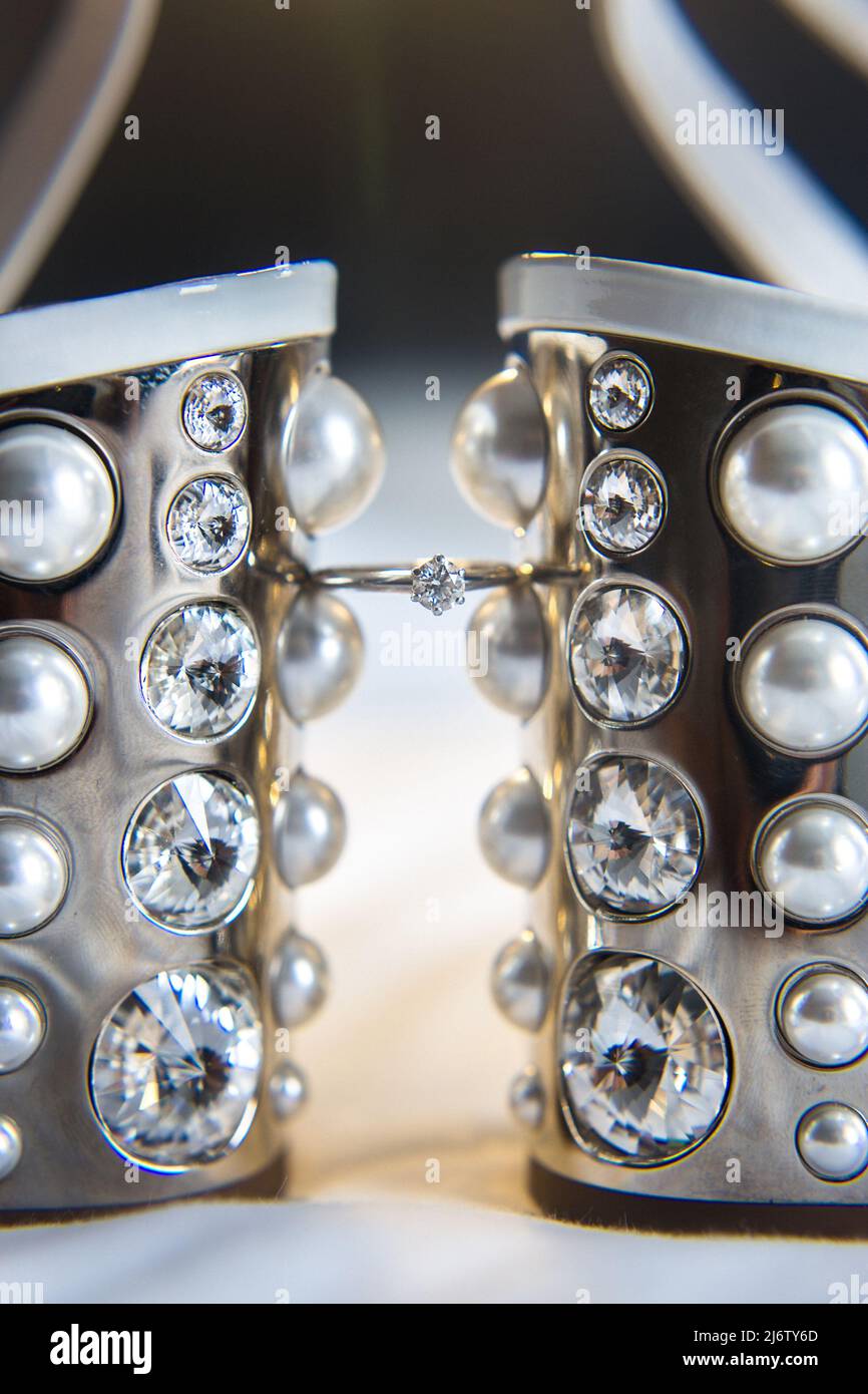 Wedding ring between wedding shoes and highlights Stock Photo - Alamy