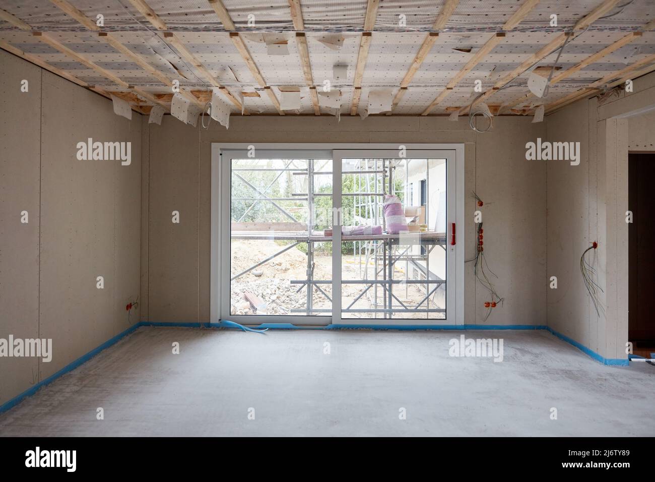 Laying screed in the living room with patio door in the house in a new ...