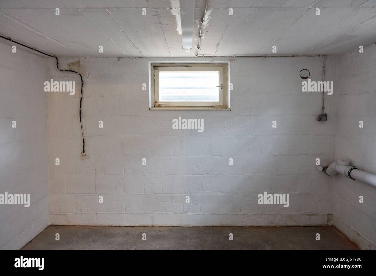 Empty room in the basement with a window as a boiler room or drying ...