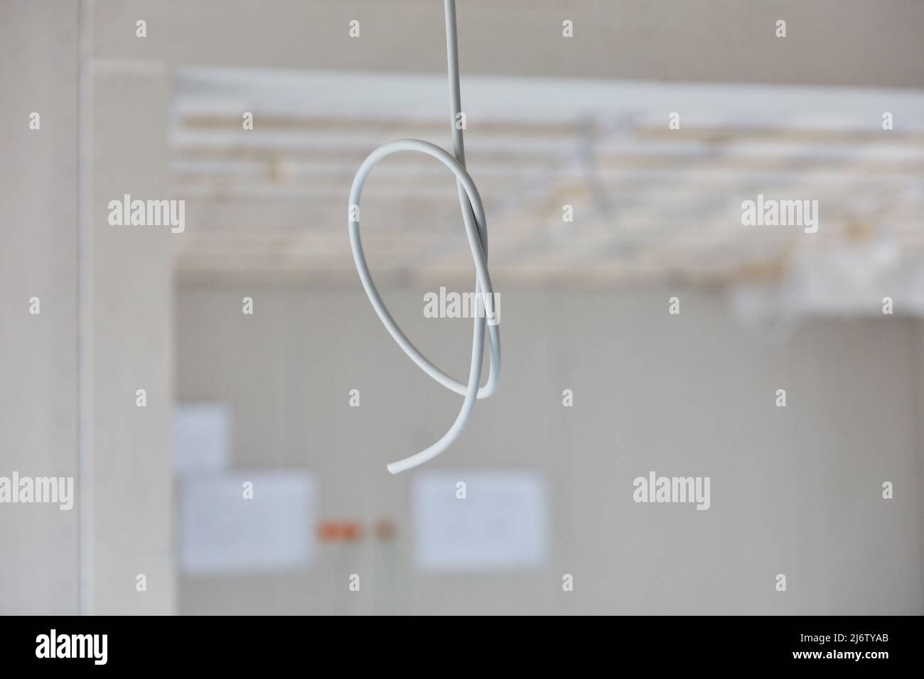 Cable with knots hangs from the ceiling in the interior of a house in a ...