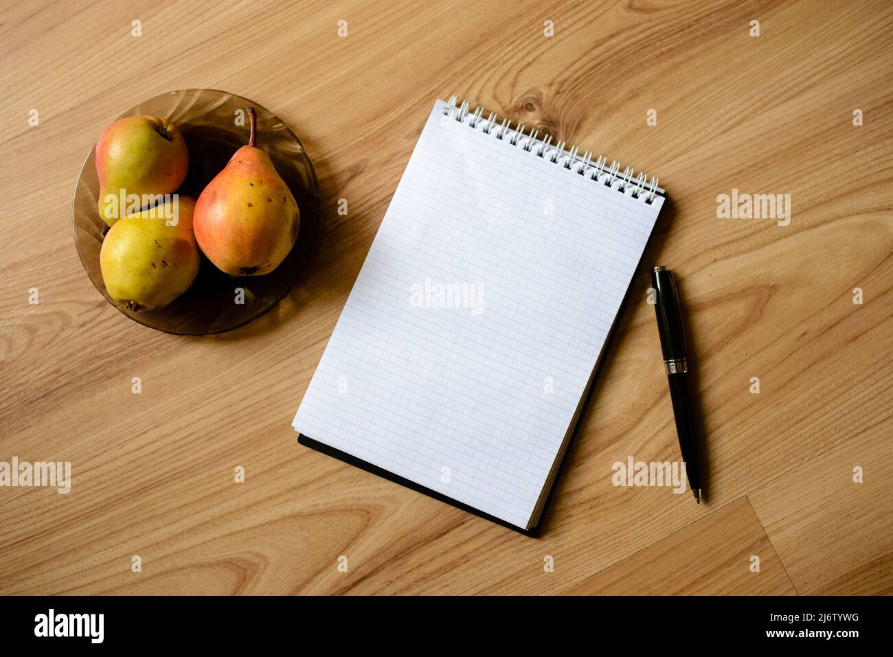 Notepad for entries on the table and fruit Stock Photo - Alamy