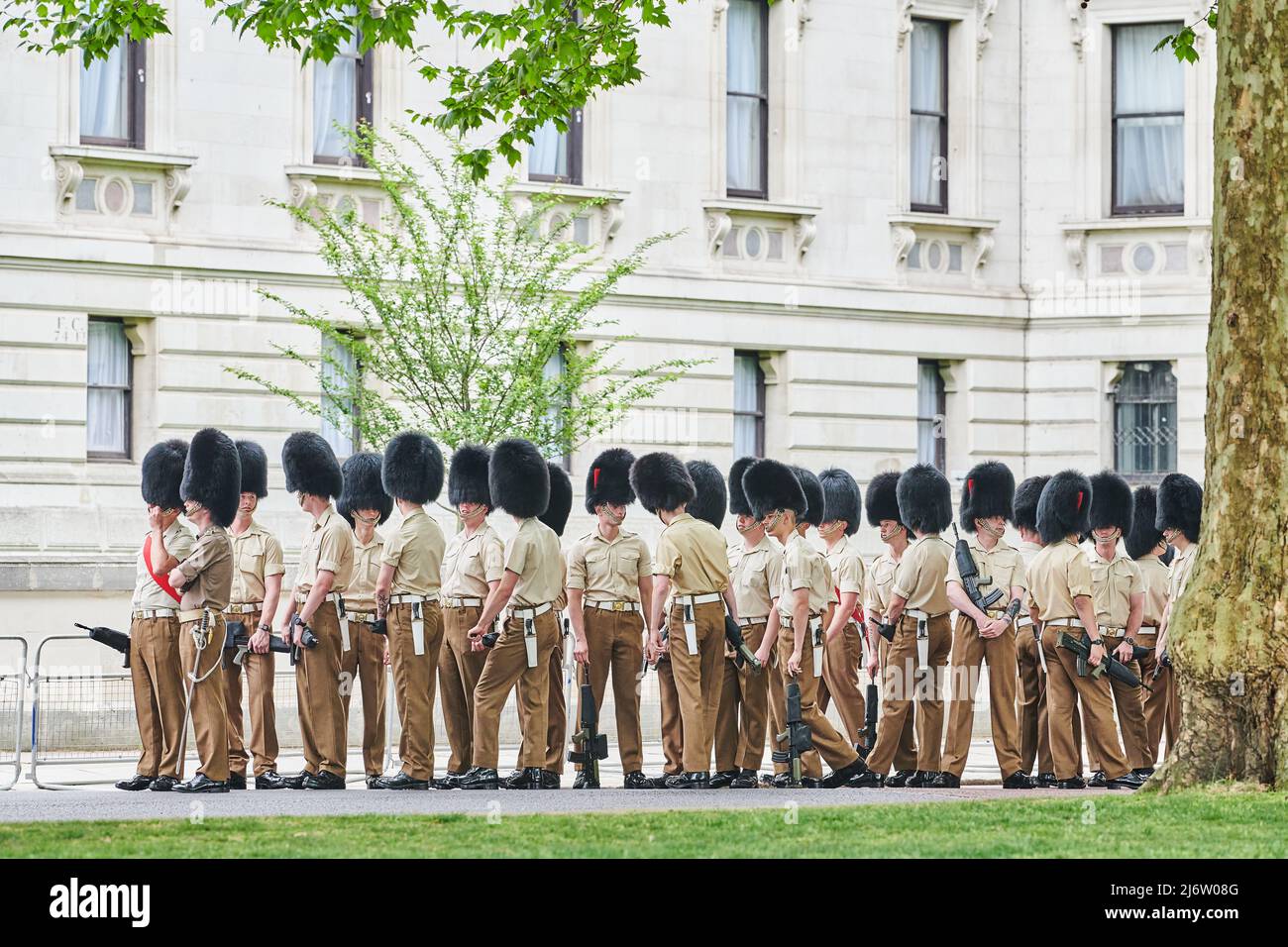The queen's guards, in their bearskin hats and with their guns, prepare ...