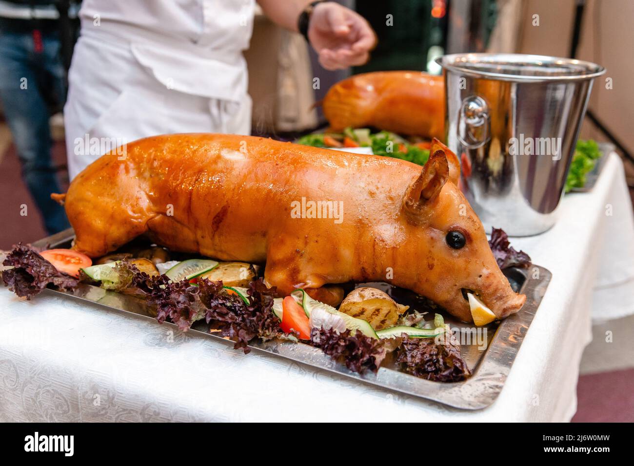 Roast pig. Roasted piglet with vegetables on platter Stock Photo - Alamy