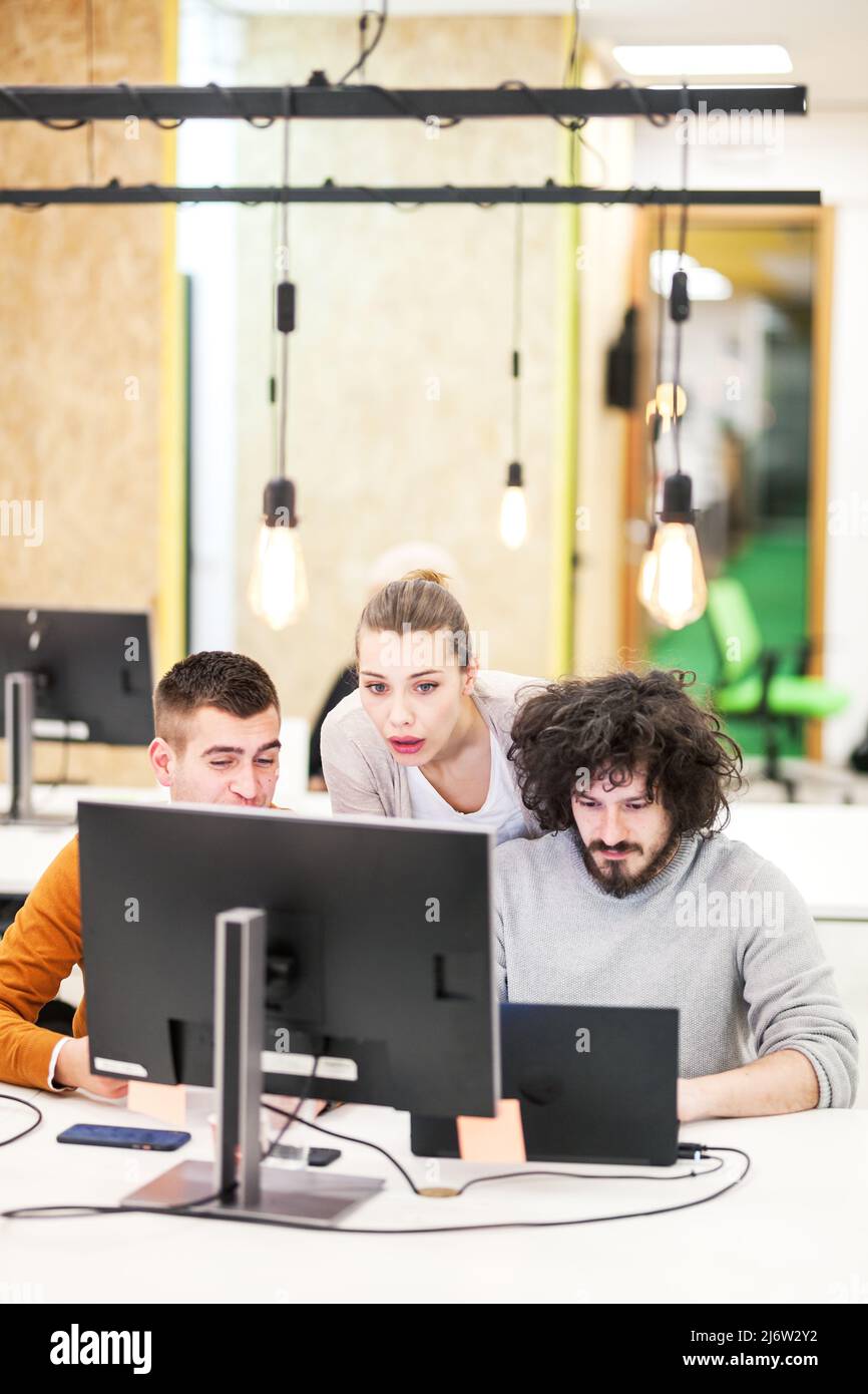 Three caucasian colleagues cheering for job well done in a modern ...