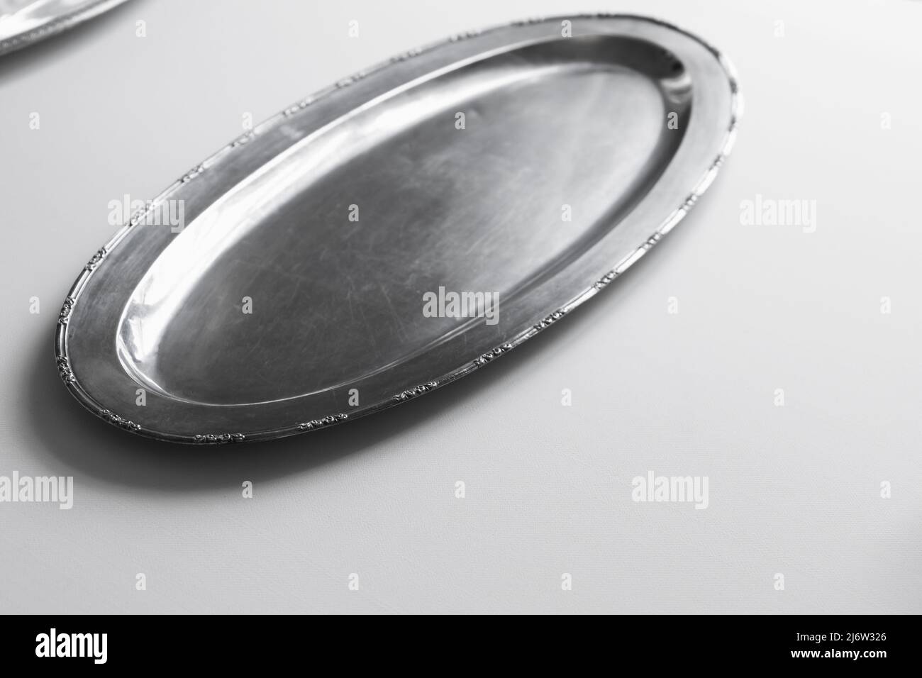 An empty silver tray is on white tablecloth, luxury vintage silverware ...