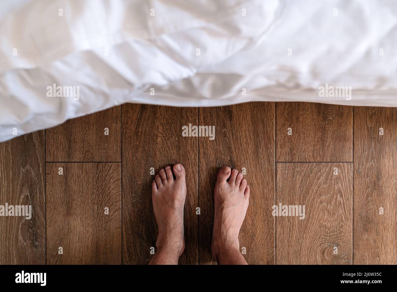 Barefoot male standing in front of the bed, top view Stock Photo - Alamy