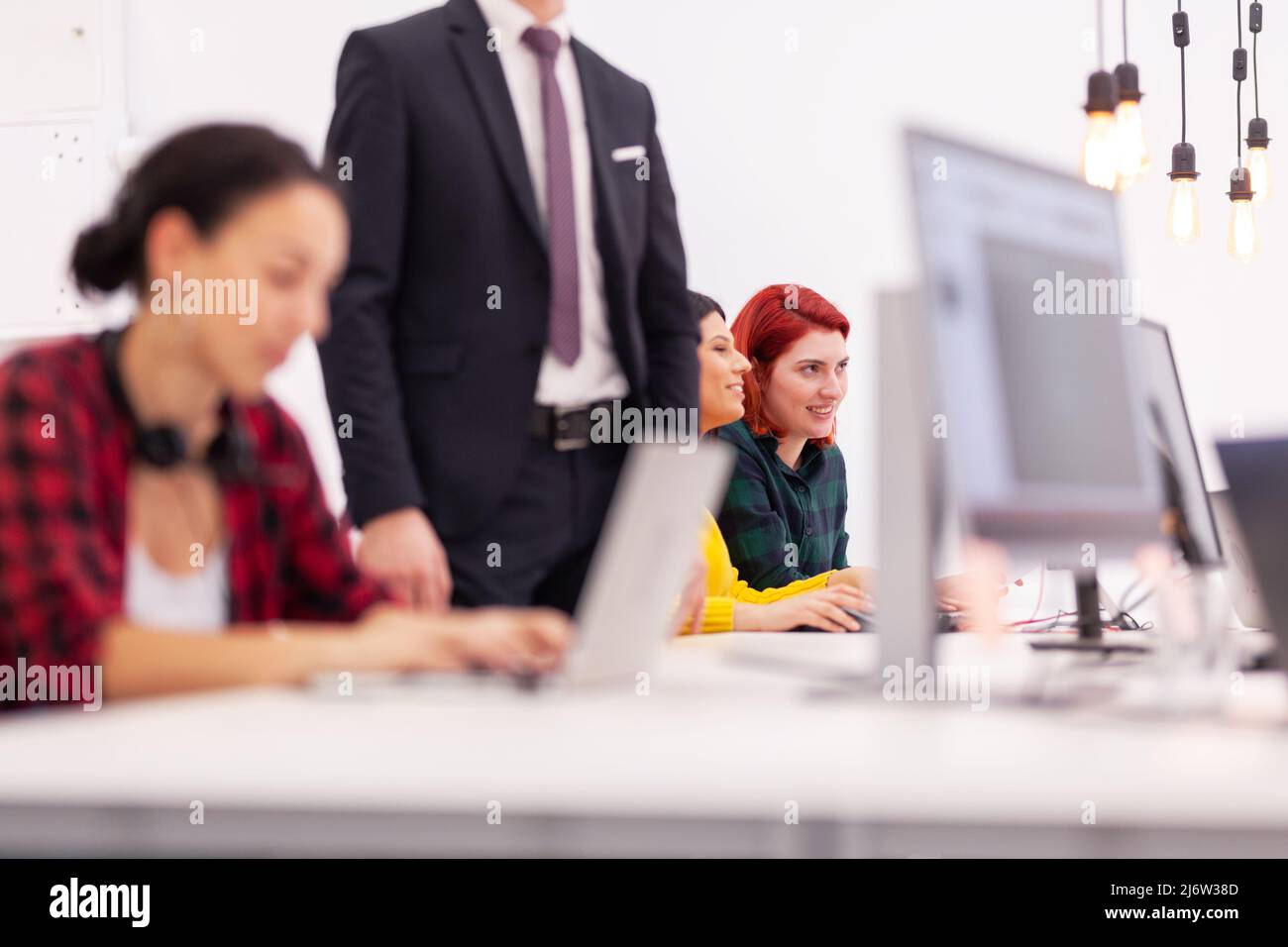 Group of multiethnic colleagues working on desktop computers in a ...
