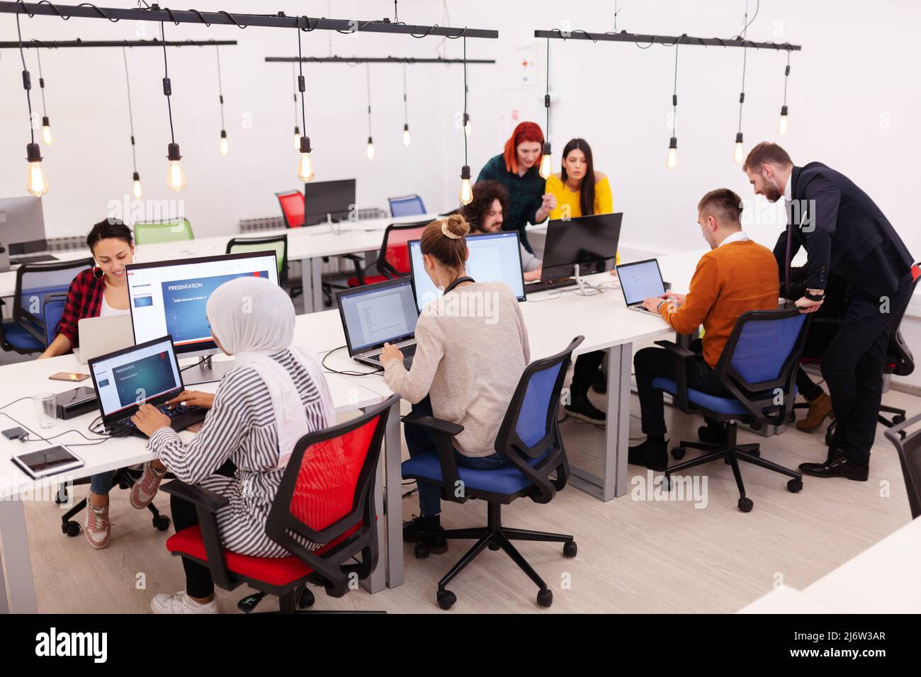 Group of multiethnic colleagues working on desktop computers in a ...