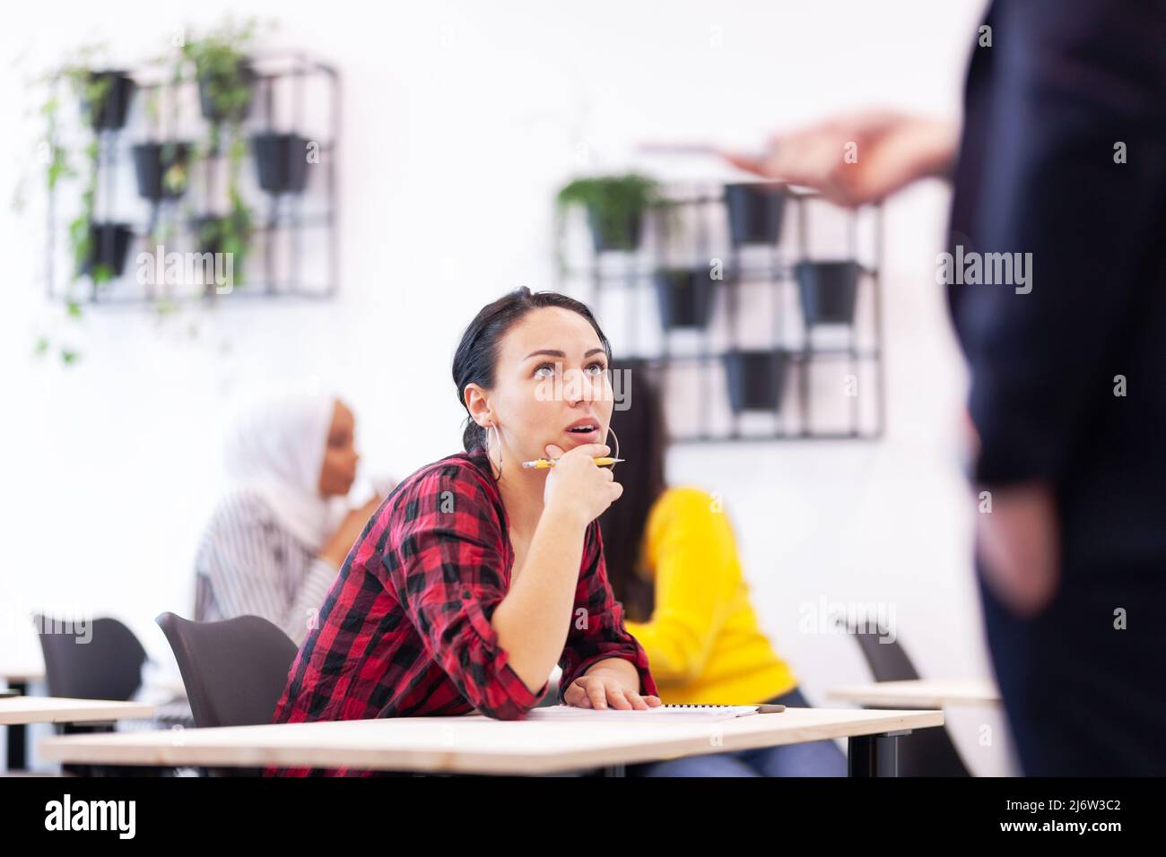 Multi ethnic students listening to a lecturer in a classroom. Smart ...