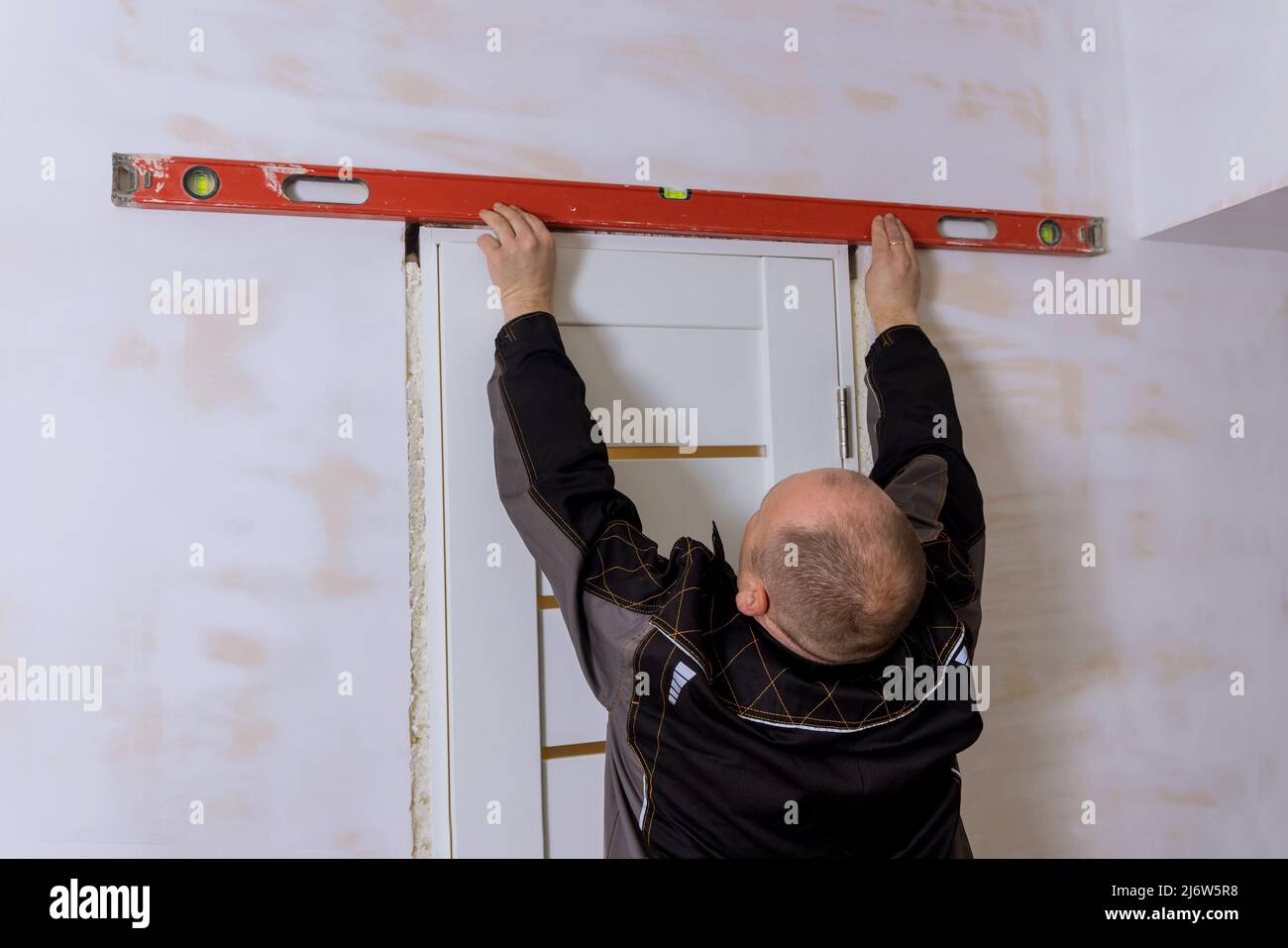 Master checks level correctness installation door Stock Photo - Alamy
