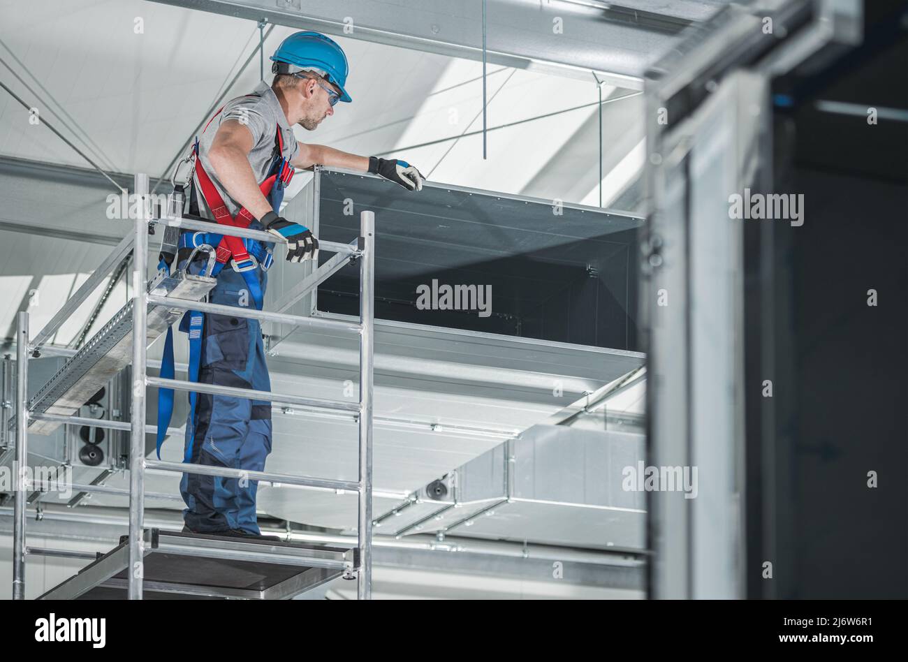 Caucasian HVAC Technician Wearing Safety Harness Performing Final ...