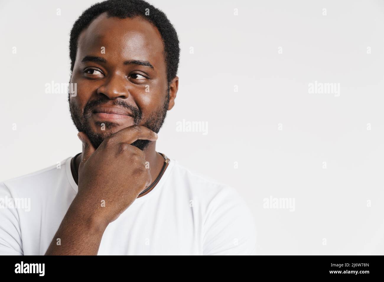 Black bristle man smiling while holding his chin isolated over white ...