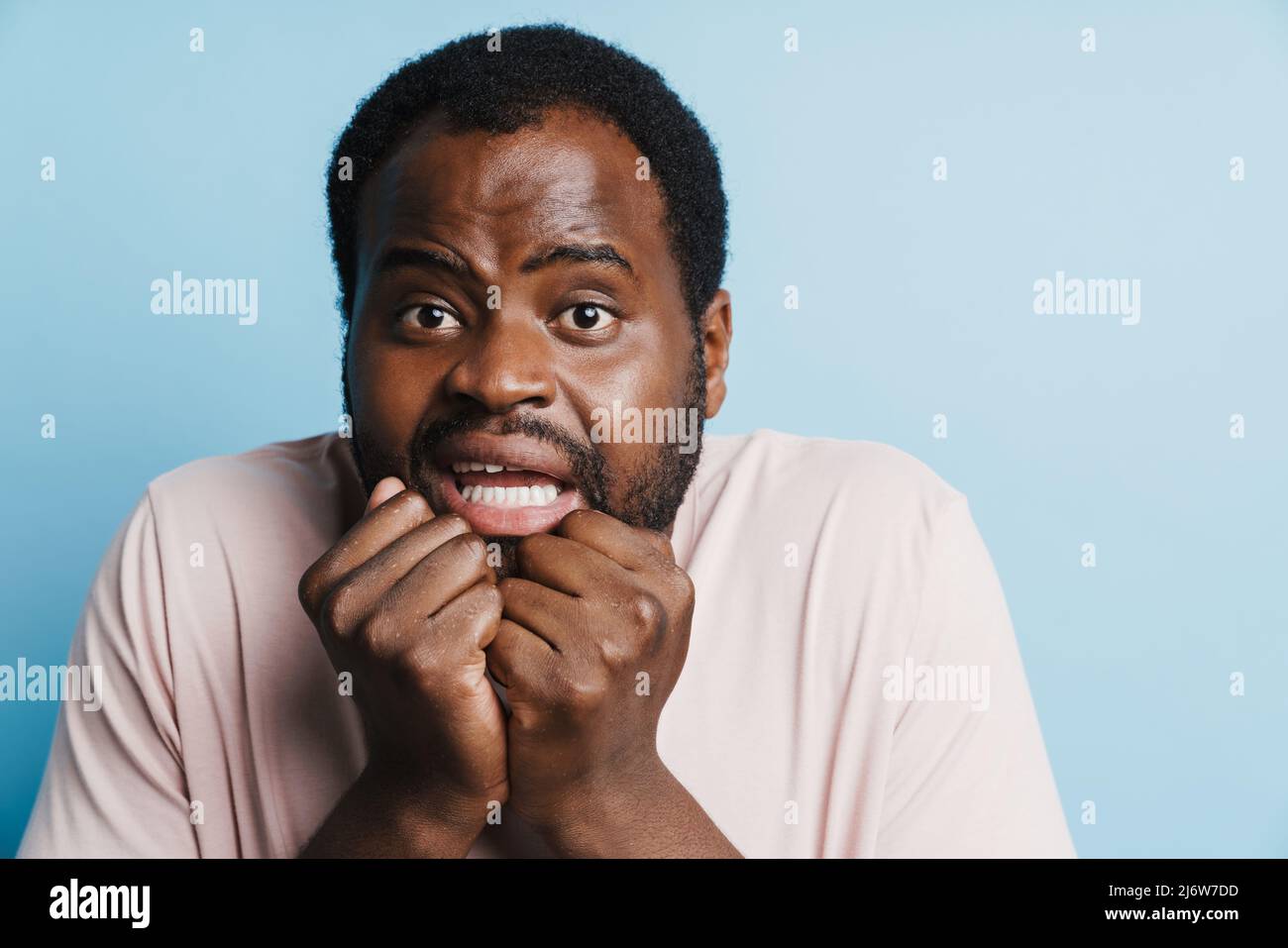 Black scared man grimacing while posing with clenched fists isolated ...