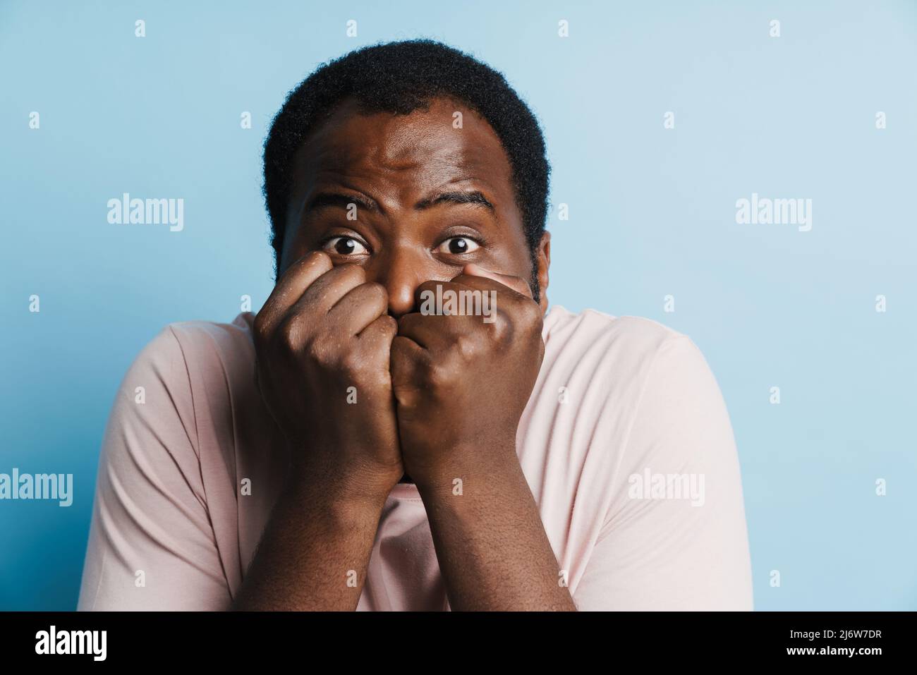 Black scared man in t-shirt posing with clenched fists isolated over ...