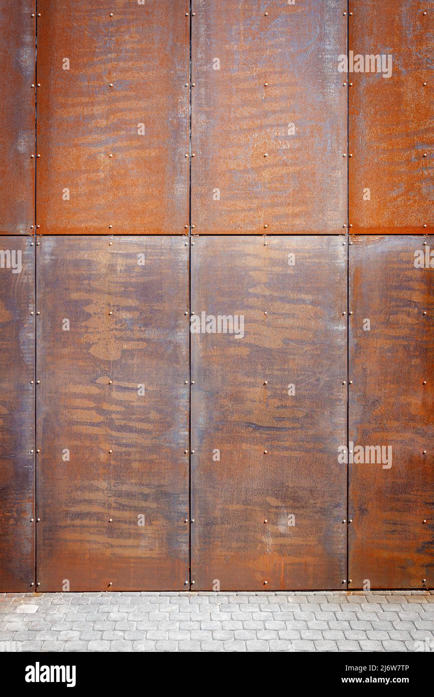 Modern architecture rusty metal wall and a sidewalk Stock Photo - Alamy