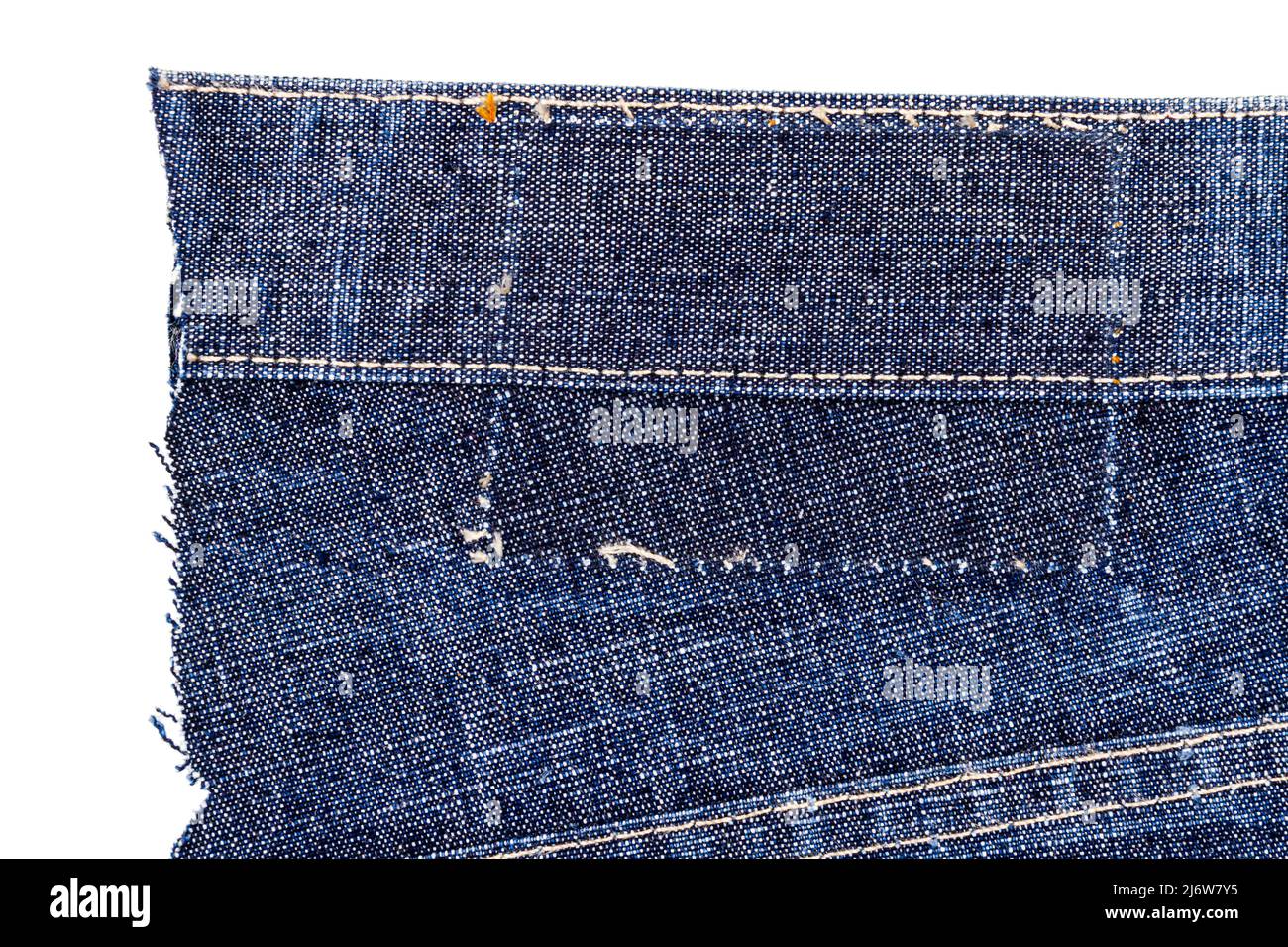 Piece of blue jeans fabric with a ripped of back pocket isolated on ...