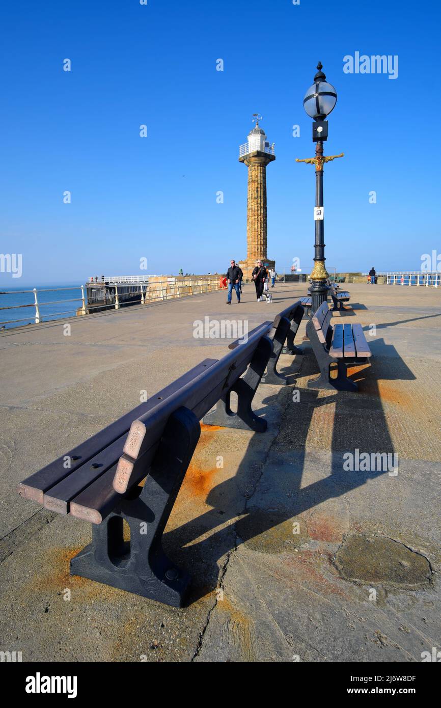Looking along the front to the lighthouse on Whitby's outer harbour in ...