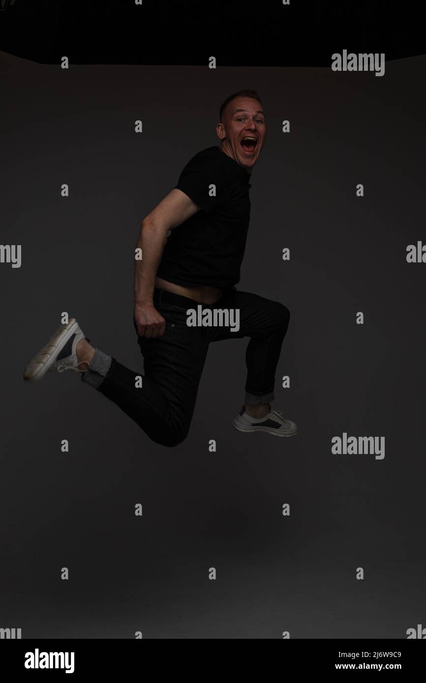 funny man jumps and rejoices in studio on white background, backstage ...