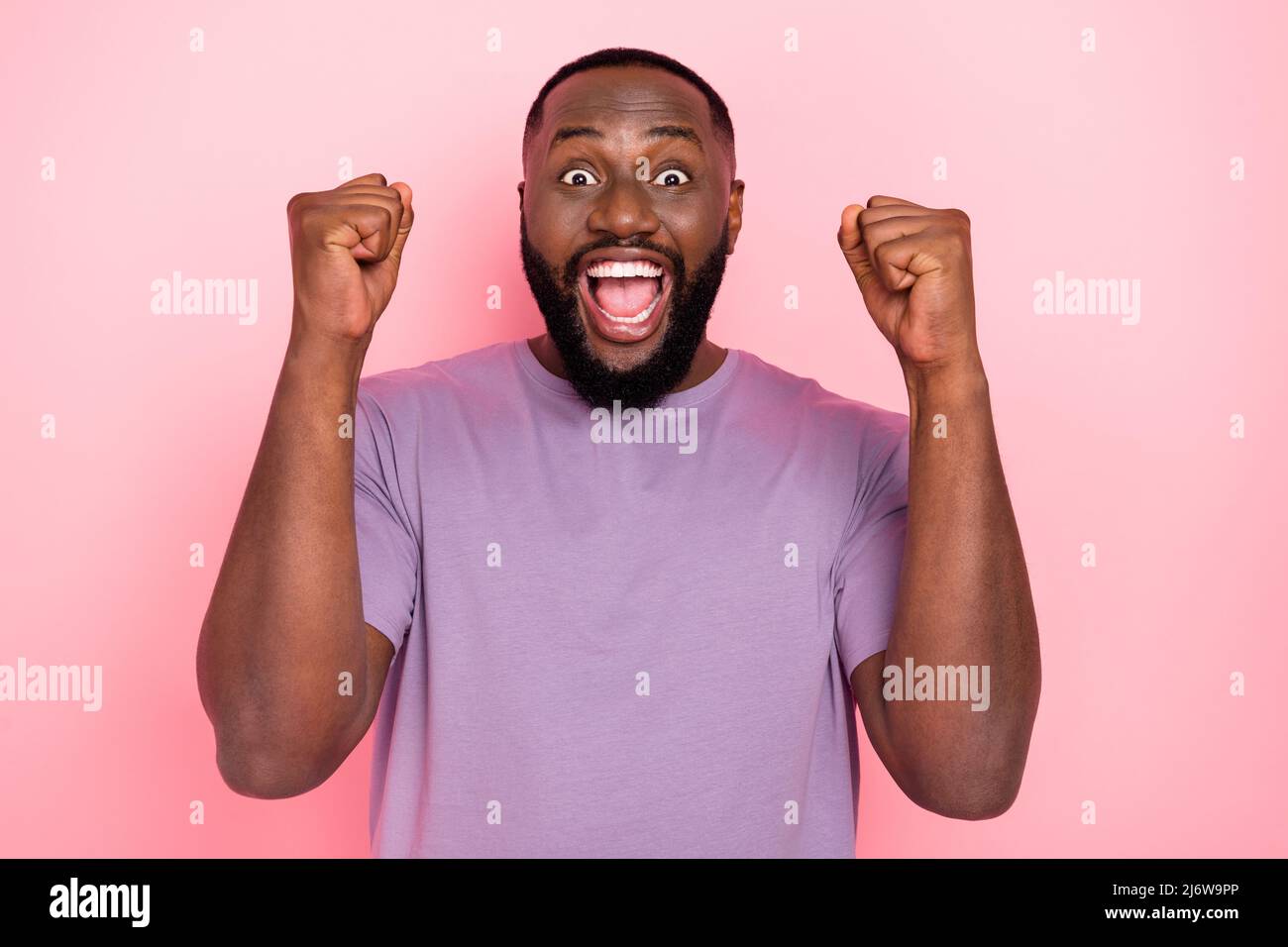 Photo of lucky funky guy dressed violet t-shirt open mouth rising fists ...