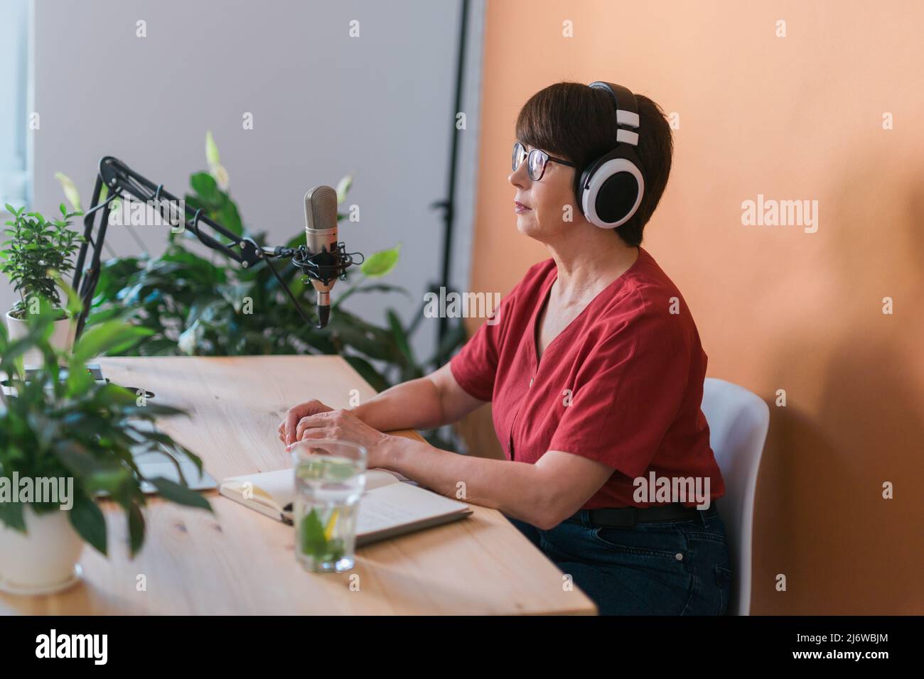 Middle-aged female radio presenter talking into the microphone and ...