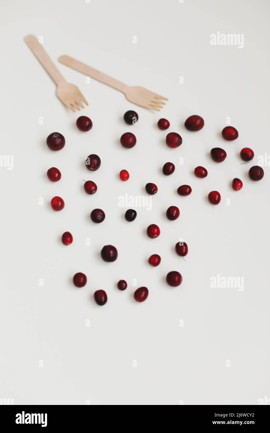 wood fork, bamboo cutlery and berries on white background, zero waste, no plastic, eco-friendly ...