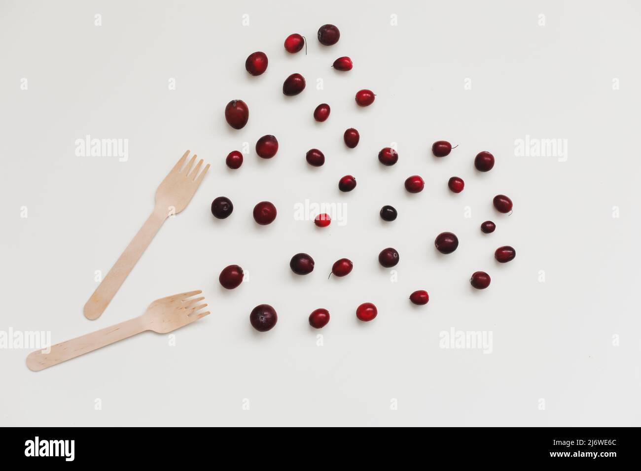 wood fork, bamboo cutlery and berries on white background, zero waste, no plastic, eco-friendly ...