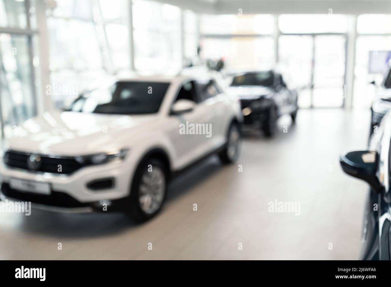 Blurred automobile dealership store interior with new luxury cars ...