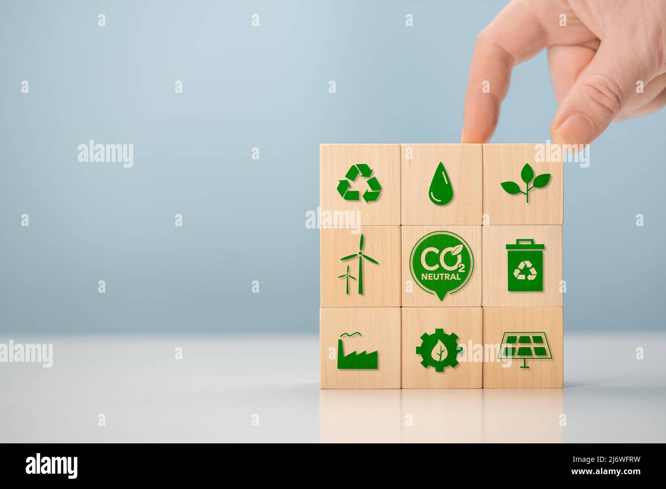Climate neutral long term strategy. Hand put wooden cubes with green ...