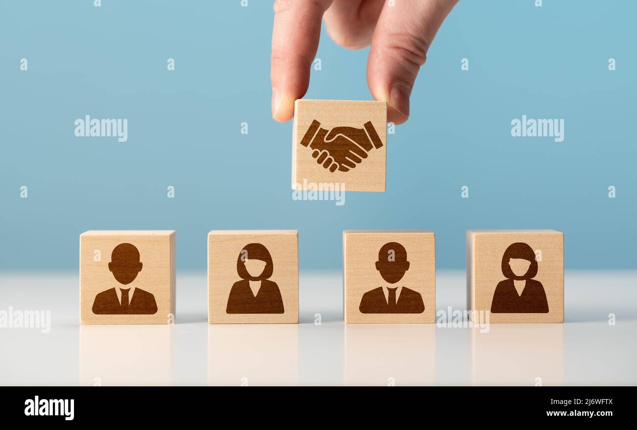 business contract. Hand putting hand shaking on wooden cube block in ...