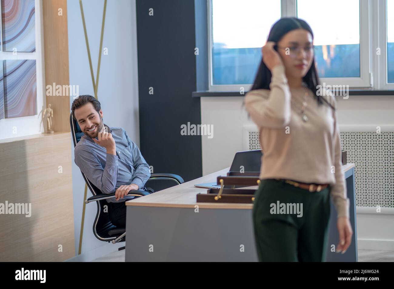 Pleased young boss staring after his secretary Stock Photo - Alamy