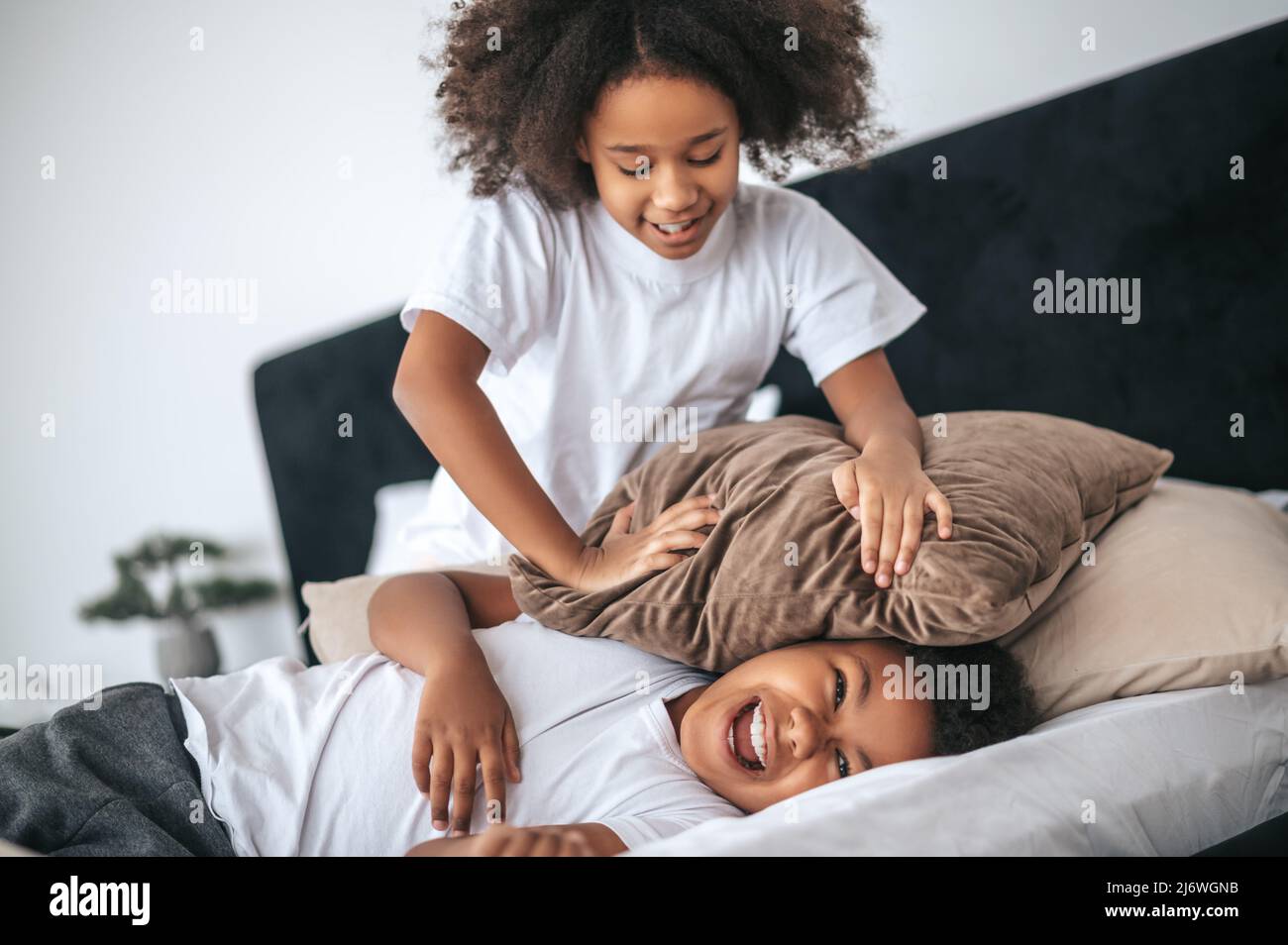 Two siblings playing together and looking excited Stock Photo - Alamy
