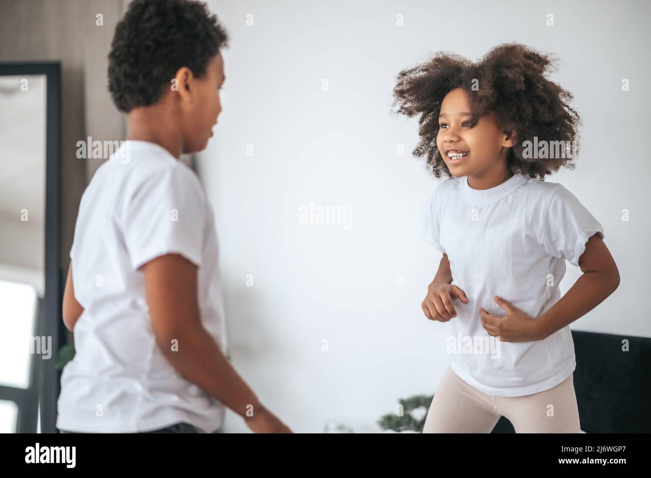 Two siblings playing together and looking excited Stock Photo - Alamy
