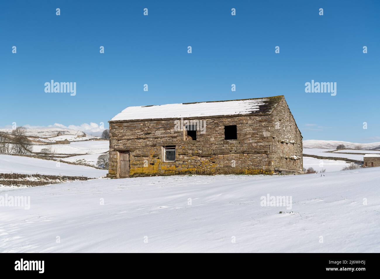 Traditional stone barns in the Yorkshire Dales, covered in snow. The ...