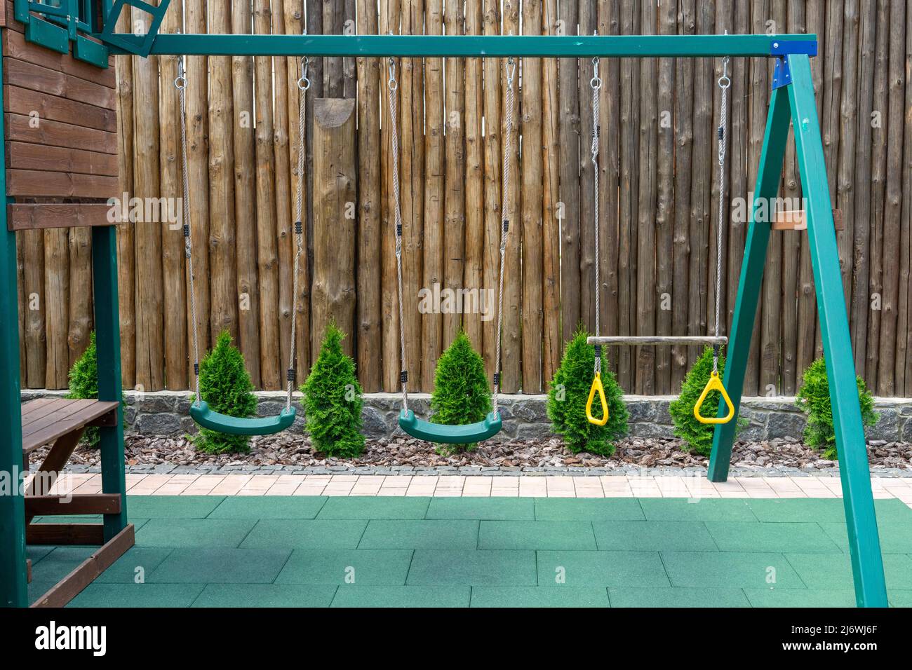 Children's swing. Playground in the yard with a fence Stock Photo - Alamy