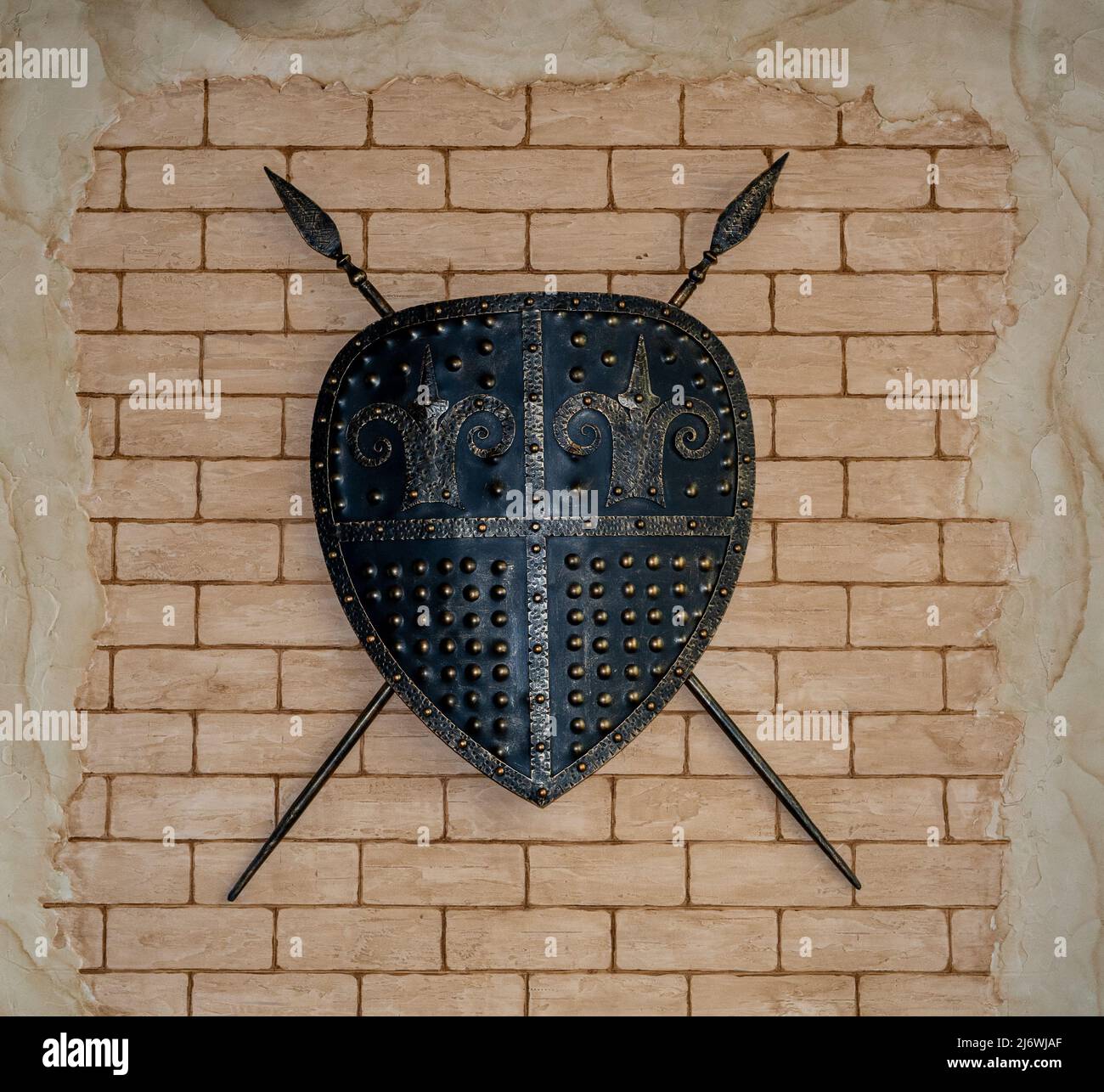 Design of an ancient castle. Brick wall. Shield and spears on the wall ...
