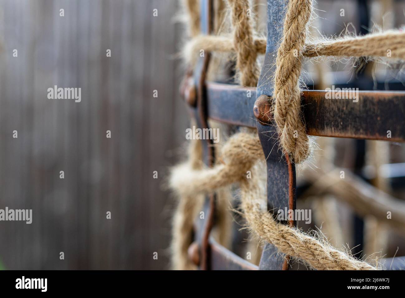 Part of the metal cage braided rope on a brown background. Place for ...