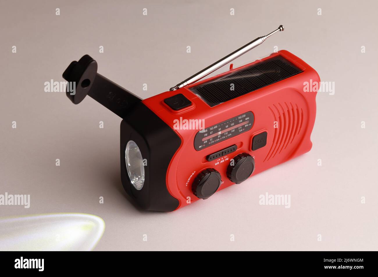 Small red portable radio rechargeable with solar panels or manually ...