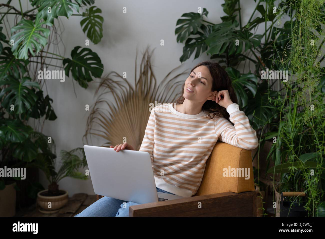 Young woman hold laptop on laps visualising good future, dreaming of ...
