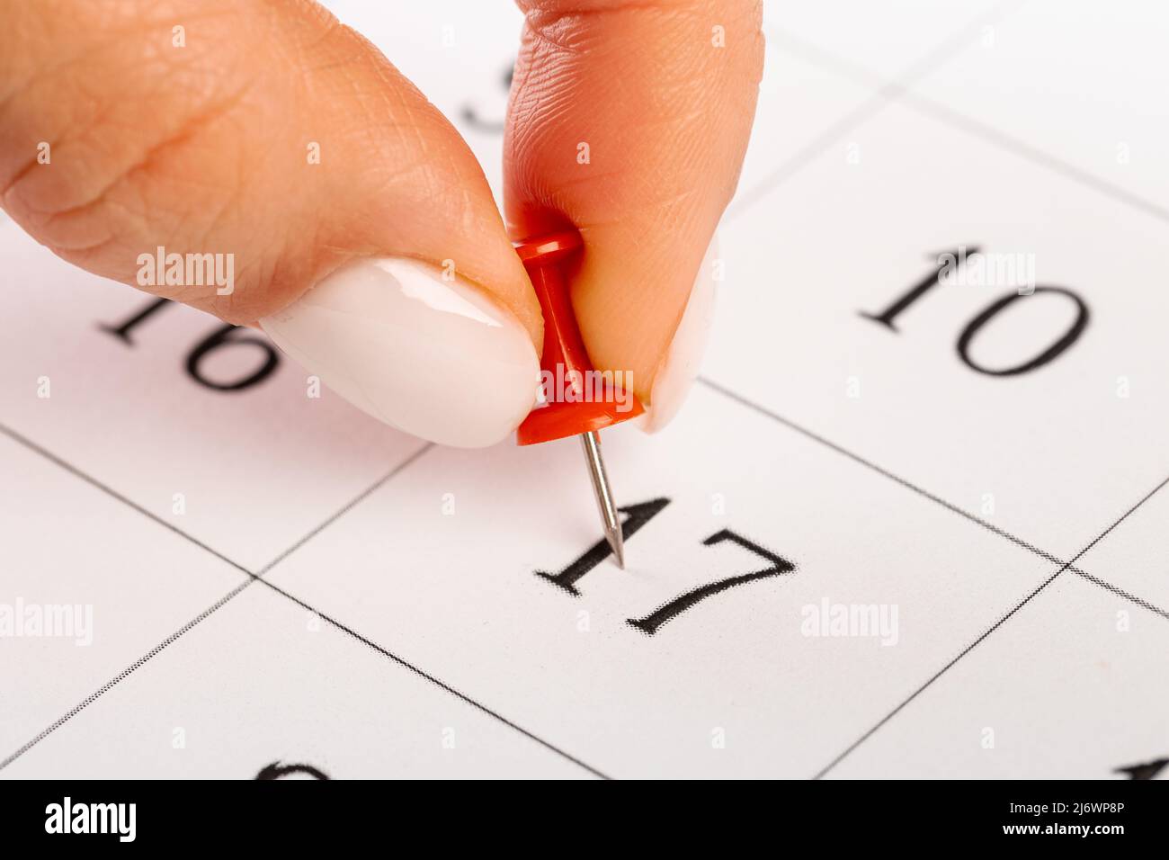 red Hand pin stuck on the day of the month in the calendar, business ...