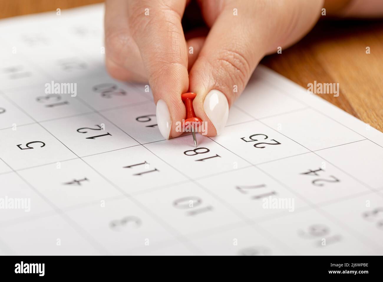 red Hand pin stuck on the day of the month in the calendar, business ...