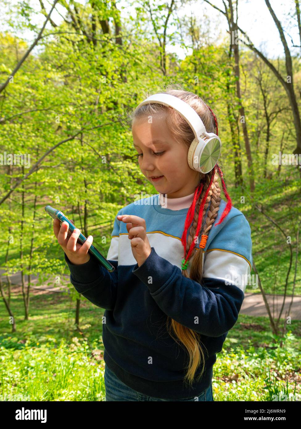 Adorable child girl in headphones learning language listening to music ...
