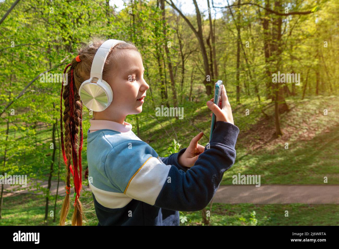 Adorable child girl in headphones learning language listening to music ...