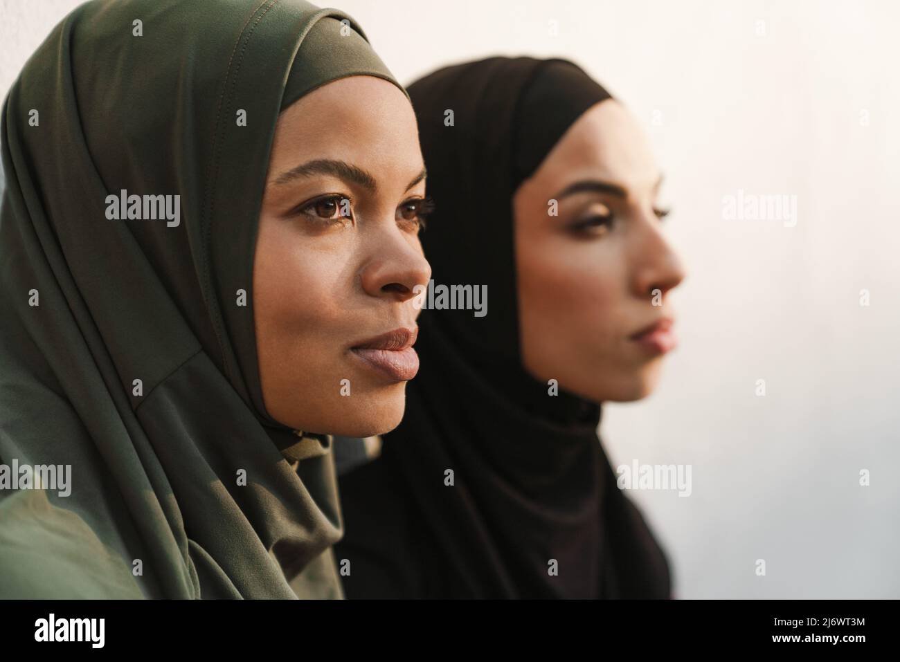 Multiracial muslim women posing and looking aside together outdoors ...