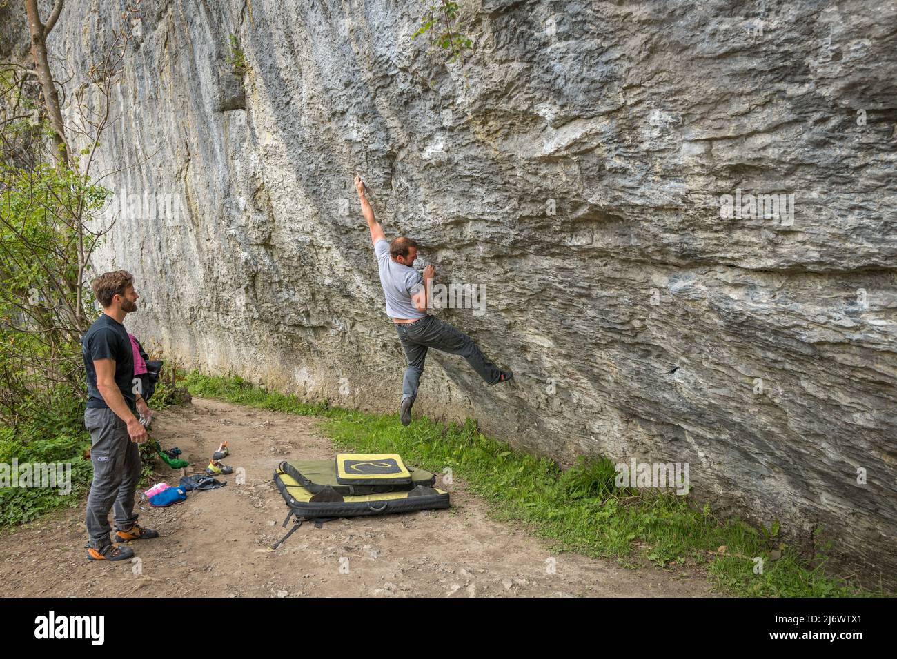 Boldering on a exposed limestone rock face in the Tideswell Dale in the ...