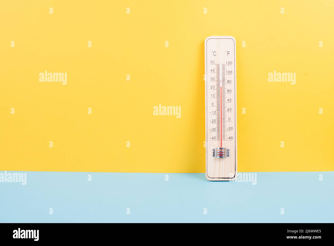 Thermometer on a yellow and blue colored background, measure the ...